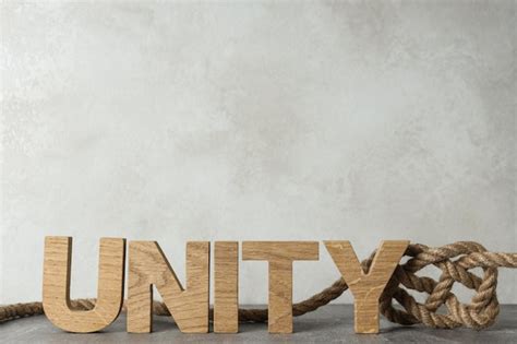 Premium Photo The Word Unity In Wooden Letters With A Rope Place For Text