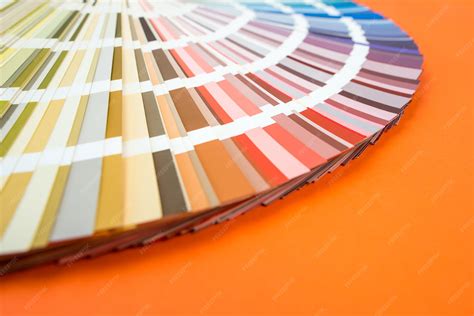 색상 가이드 닫기 디자인을 위한 다양한 꽃 주황색 배경의 색상 팔레트 팬 그래픽 디자이너가 색상 팔레트 가이드에서 색상을 선택합니다 색상 견본 카탈로그 프리미엄 사진