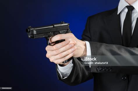 총기 및 보안 주제 고립 된 스튜디오에 진한 파란색 배경에 총을 들고 검은 양복에 남자 겨냥에 대한 스톡 사진 및 기타 이미지 겨냥 경호 권총 Istock