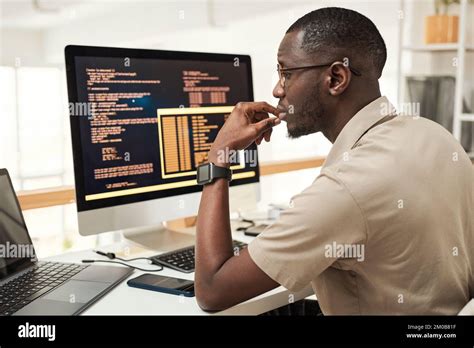 Pensive Software Engineer Reading Programming Code On Laptop Screen