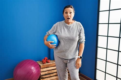 Mulher Hispânica De Meia Idade Segurando Bola De Pilates Assustada E