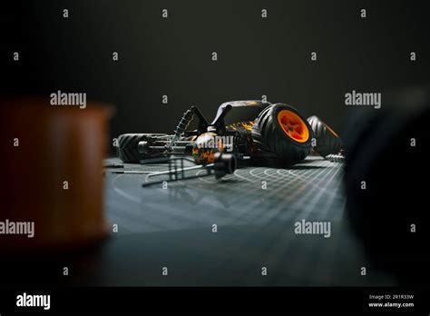 Disassembled Remote Controlled Car Laying On A Cutting Mat Desk In A Lamp Spotlight With Parts
