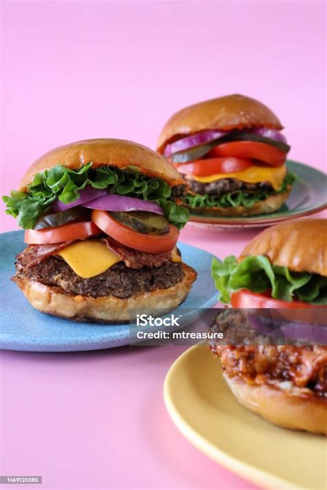 청록색 노란색 및 녹색 접시 햄버거 패티 베이컨 러셔 녹는 가공 치즈 조각과 샐러드 분홍색 배경 전경에 초점 바로 먹을 수