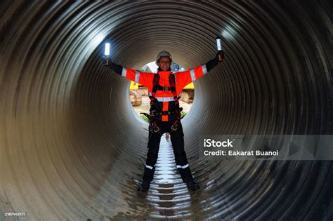 여성 엔지니어가 대형 강관 내부에서 일하고 있습니다 작업자들은 산업 플랜트에서 석유 천연 가스 및 연료를 운송하기 위한 파이프라인을 건설합니다 강철에 대한 스톡 사진 및