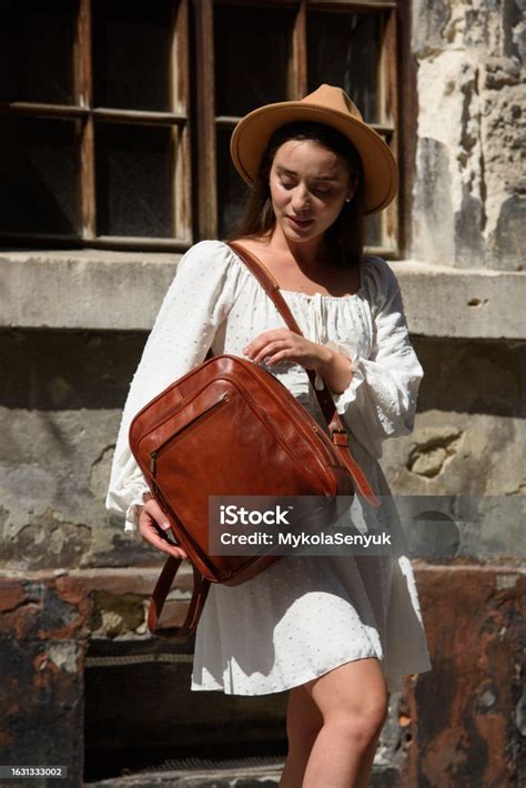 흰색 낭만적인 여름 드레스와 베이지색 모자를 쓰고 고급 가죽 배낭을 메고 포즈를 취하는 갈색 머리 가방에 대한 스톡 사진 및 기타 이미지 Istock
