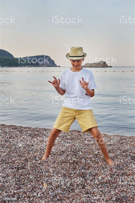 쾌활한 십대는 얼굴을 만들고 조약돌 해변을 따라 걷습니다 여행과 여행의 개념 10 11세에 대한 스톡 사진 및 기타 이미지 10 11세 T 셔츠 공란 Istock