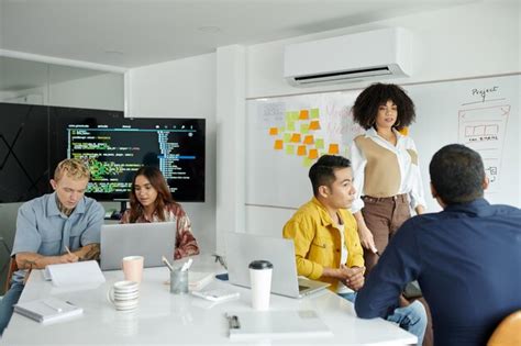 Premium Photo Team Working On New Big Project Discussing Programming Code And Mobile App Interface