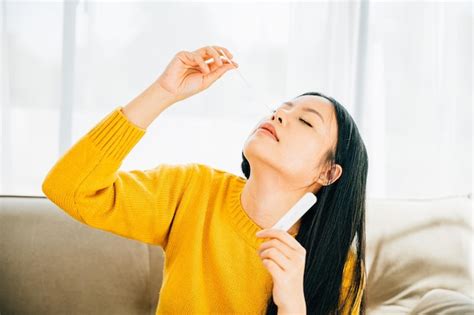 Premium Photo Woman At Home Uses A Rapid Antigen Test Kit Inserting A