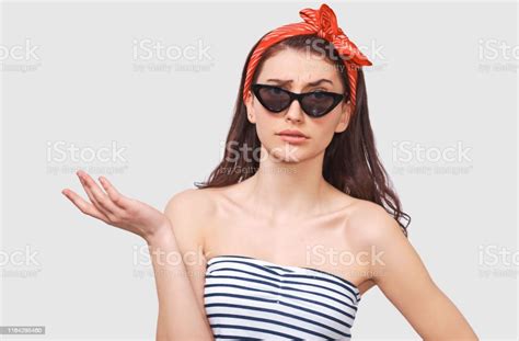 사려 깊은 젊은 여성 대화 중에 심각한 찾고 캐주얼 트렌디 한 의상을 입고 흰색 벽에 포즈 학생 소녀는 혼란스러운 표정을 가지고 있습니다 사람들의 감정 T 셔츠에 대한 스톡