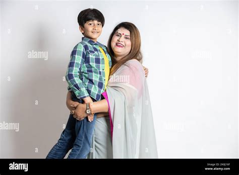 Portrait de la mère indienne heureuse et son fils regardant l appareil photo isolé sur fond