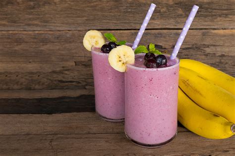 블루베리 믹스 바나나 스무디 보라색 다채로운 과일 주스 밀크 블렌드 음료 건강 한 고 단백 나무 배경에 유리 음료 에피소드 아침에 맛 있는 맛 건강한 생활방식에 대한 스톡