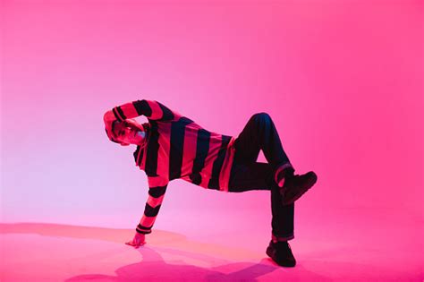 스튜디오에서 점퍼 댄스 현대 무용을 입은 청년 브레이크 댄스 댄스 스쿨 포스터입니다 공간을 복사합니다 전투 대회 발표 분홍색과 파란색 배경입니다 공연에 대한 스톡 사진 및