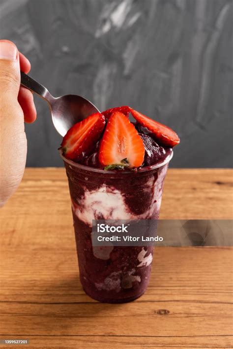 딸기와 응축 우유플라스틱 컵에 브라질 냉동 아사이 베리 아이스크림 스무디 한 숟가락을 복용 남자 여름 배경에 메뉴 및 소셜 미디어에 대한 전면 보기 0명에 대한 스톡 사진