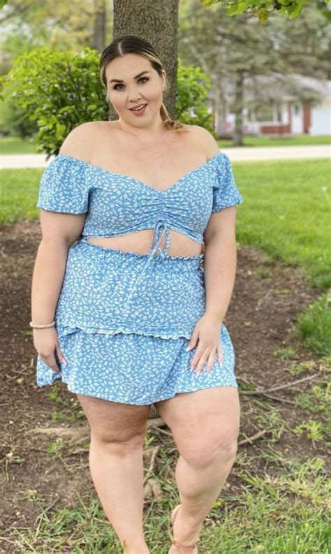 A Woman In A Blue Dress Standing Next To A Tree
