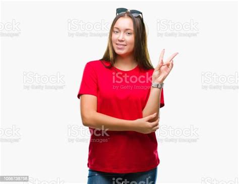 젊은 아름 다운 백인 여자 승리 표시를 하 고 카메라에 윙크 하는 행복 한 얼굴로 웃 고 고립 된 배경 위에 선글라스를 착용