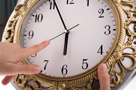 Premium Photo Hand In Touch With A Clock On A White Background