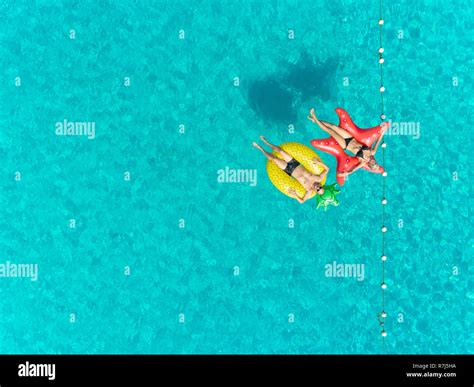 Aerial View Of Man And Woman Floating By String Buoy On Inflatable