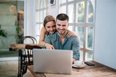 Couple Looking At Laptop Computer Together At Home The Concept Of Couples Sharing One Idea