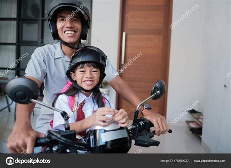 Father Taking His Daughter To School By Motorcycle In The Morning