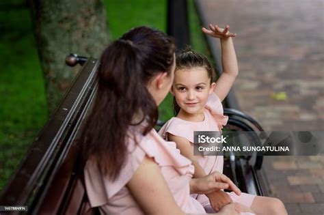 여름에 공원에서 걷고있는 어머니와 딸 56 세 어머니는 벤치에 앉아있는 딸에게 이야기 행복한 가족의 개념 어머니와 아이의 관계 어머니의 날 2 3 살에 대한 스톡 사진 및