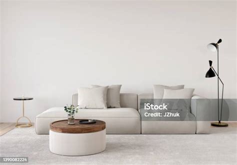 베이지 색 톤의 거실에는 소파 플로어 램프 나무 테이블 및 금색 사이드 테이블이 있습니다 거실에 대한 스톡 사진 및 기타 이미지