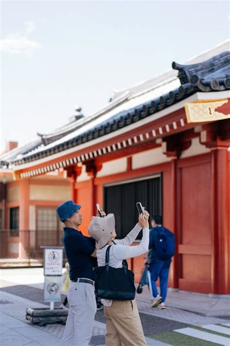 무료 도쿄의 한 사찰에서 하루를 즐기며 스마트폰으로 추억을 포착하는 관광객들 스톡 사진