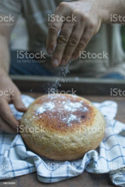 베이커의 손이 신선한 빵에 밀가루를 뿌린다 한 남자가 베이킹을 마치고 따뜻한 빵을 장식합니다 전통 마을 레시피 홈 베이킹 컨셉 가루로 빻은에 대한 스톡 사진 및 기타 이미지