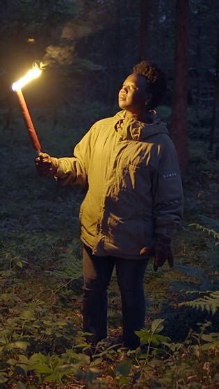 A Person Is Holding A Torch While Navigating Through A Dark And Mysterious Forest Area 52668414