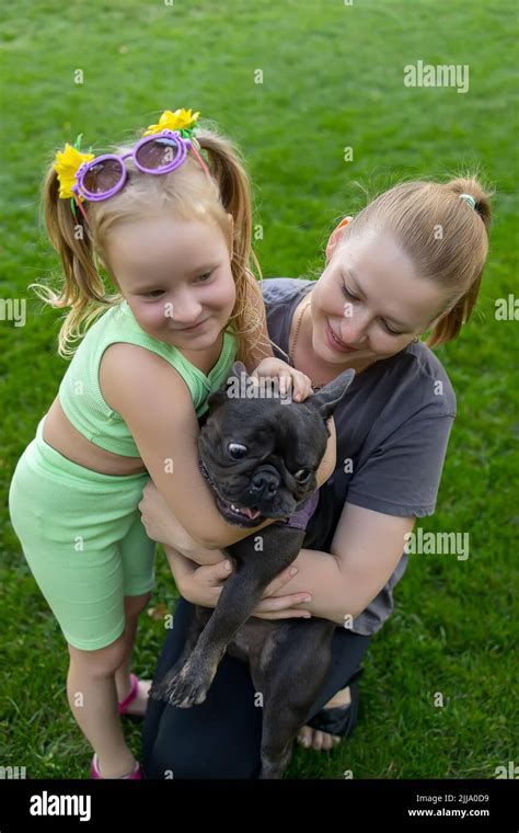 Mutter Und Kleine Tochter Sitzen Auf Dem Rasen Im Park Und Umarmen Den