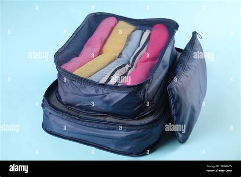 Packing Cubes With Clothes On Light Blue Background Closeup Stock