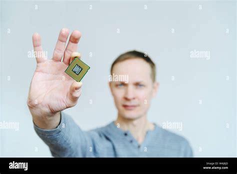 The Processor Is In The Man S Hand A Man Is Holding A Processor Between Two Fingers Stock Photo