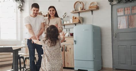어린 소녀의 뒷모습 장난기 많은 여자 아이는 낮에 어머니와 아버지 앞에서 부엌에서 뛰어 다니며 재미있게 놀고 있습니다 사진 Unsplash의 실내 이미지