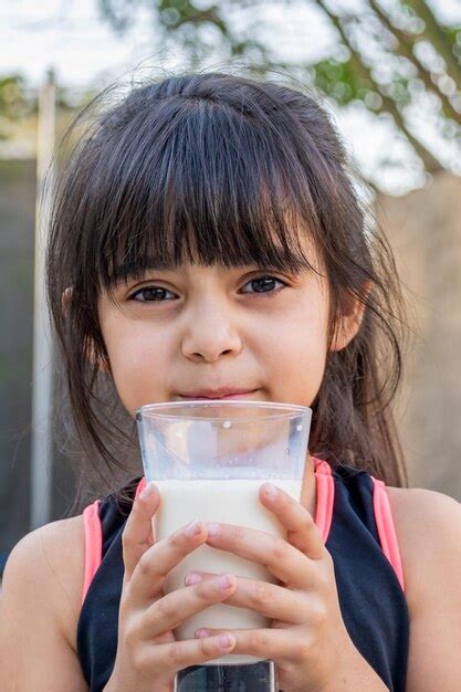 Premium Photo Closeup Portrait Of Her She Drinks A Glass Of Cold Milk After Playing Outside