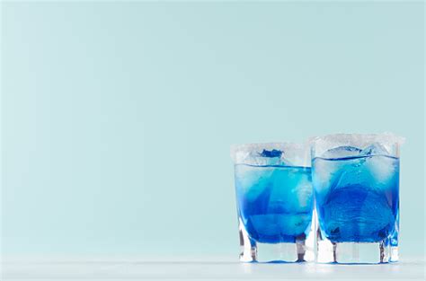 화이트 우드 테이블에 민트 컬러 바 내부에 블루 큐라소 얼음 큐브 설탕 테두리와 해변 스타일의 축하절한 블루 칵테일 0명에 대한 스톡 사진 및 기타 이미지 Istock