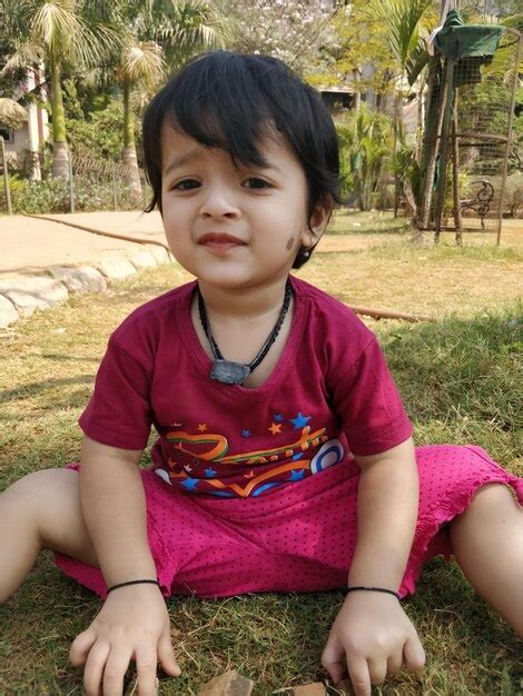 Premium Photo Portrait Of Cute Girl Sitting Outdoors