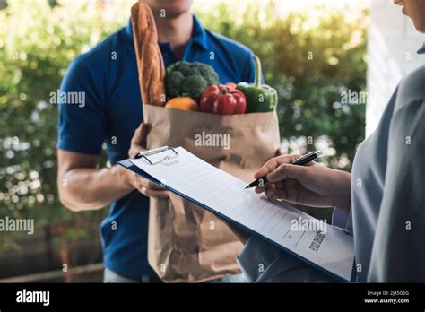 Asian Woman Is Checking The Product And Signing The Receipt On The Order Receipt Through The