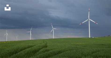 배경에 풍력 터빈이 있는 푸른 잔디밭 사진 Unsplash의 무료 기계 이미지