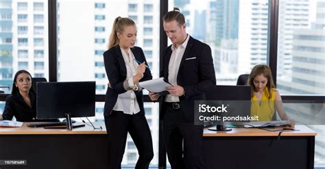 양복을 입은 비즈니스 사람들은 사무실 도시 건물 보기에서 회의하고 있습니다 프로젝트에 대한 아이디어를 파트너와 공유하기 위해 일하는 비즈니스 팀 그룹 경영자에 대한 스톡