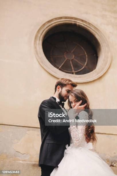 세련된 신부와 신랑은 부드럽게 유럽 도시 거리에서 포옹 고대 건물 근처포옹 신혼 부부의 화려한 결혼식 부부 로맨틱한 순간 결혼식 날 25 29세에 대한 스톡 사진 및 기타