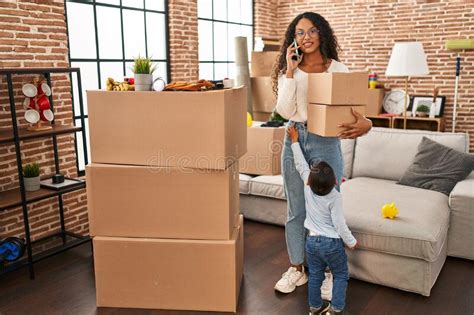 Mother And Son Talking On The Smartphone Holding Package At New Home Stock Image Image Of