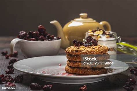 흰색 접시에 배치 된 여러 시리얼 비스킷 가로 사진 플레이트에 적색 잼이 흘 렸 습니다 드라이 레드 크랜베리는 흰색 컵에 있으며 어두운 나무 보드에 쏟아 졌습니다 0명에