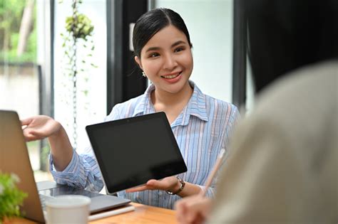 아시아 사업가가 태블릿 화면을 통해 동료에게 프로젝트를 제시합니다 25 29세에 대한 스톡 사진 및 기타 이미지 25 29세 2명 말하기 Istock