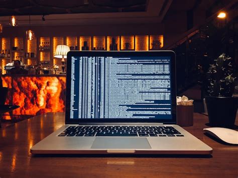 premium photo computer code on laptop screen at table