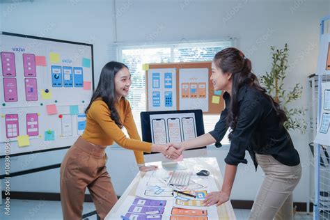Two Smiling Asian Ui Ux Designers Shaking Hands After A Successful Meeting In Their Office
