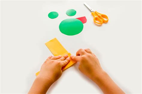 Diy와 어린이의 창의성의 개념 단계별 지시 종이에서 아플리크 개구리를 만드는 방법 3단계 자식이 용지를 구부립니다 선택적 초점