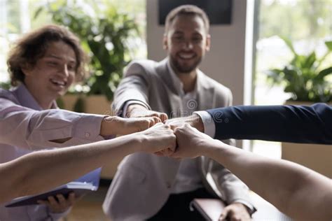 happy teammates showing unity joining fists together stock image