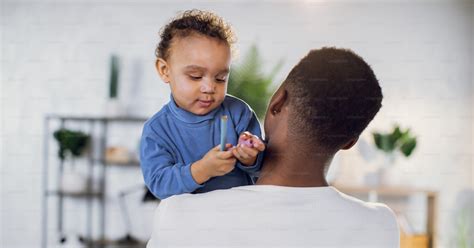 카메라를 바라보는 손에 귀여운 작은 아들을 안고 있는 아프리카 아버지의 뒷모습 집에서 행복한 활동적인 주말 가족 시간 사진 Unsplash의 우크라이나 이미지