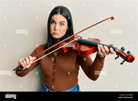 Young Brunette Woman Playing Violin Depressed And Worry For Distress