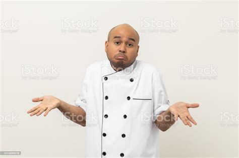 고립 된 배경에 유니폼을 입은 젊은 잘 생긴 아시아 남자 요리사를 이해하지 못하는 척하십시오 혼란스러운 요리 인도 남자 직업