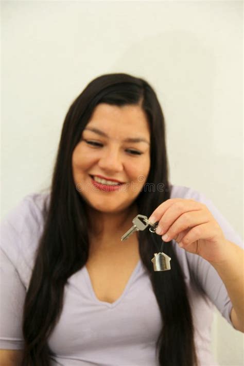 Latin Adult Woman Shows The Keys To Her New Home On A House Shaped